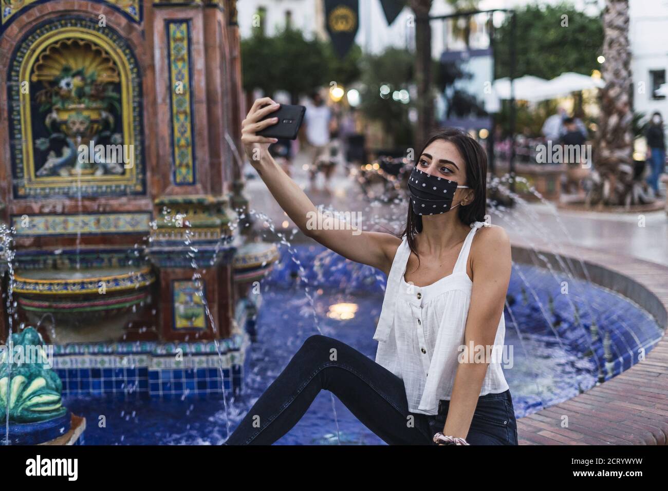 Closeup shot of a female taking a selfie while wearing a face mask ...