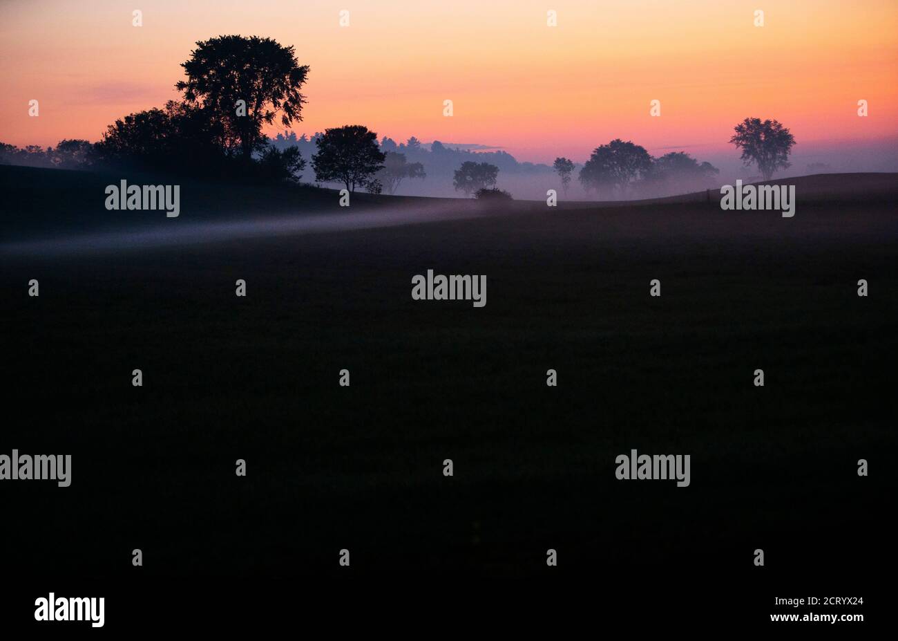 Dawn's early light illuminates morning ground fog on farm land Stock ...