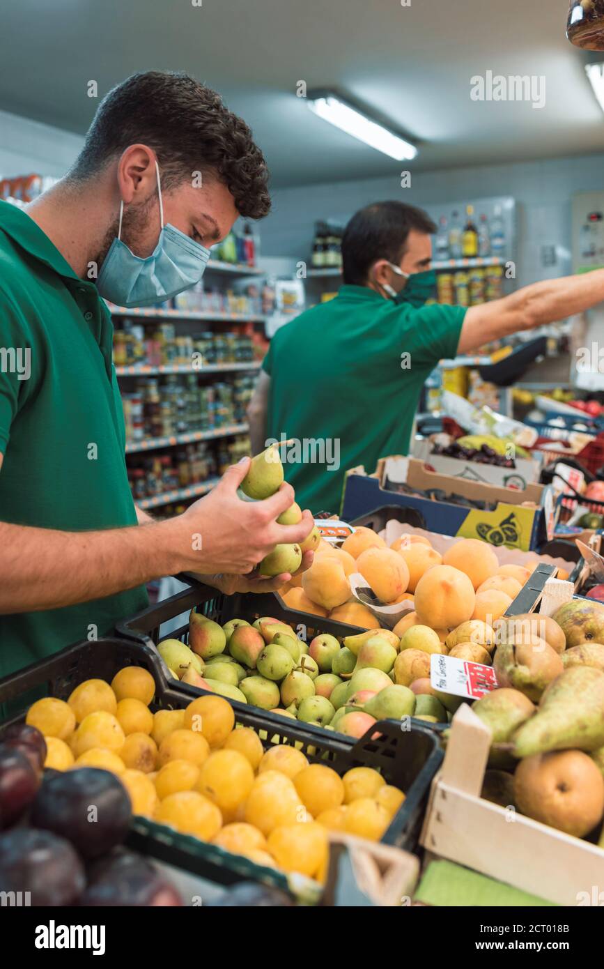 two men selling fruit picking fruit from the stall. Fruit concept Stock ...