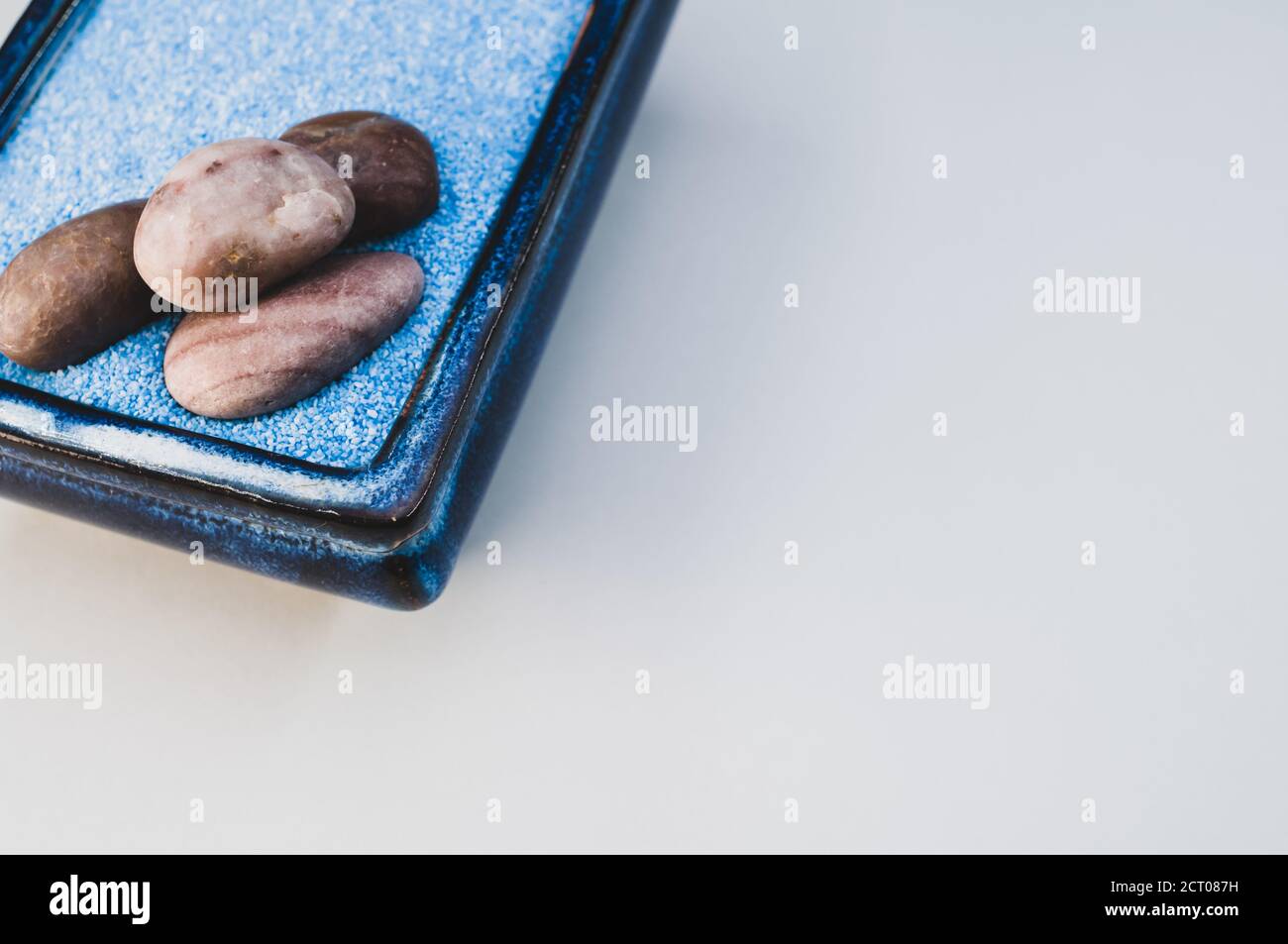 Top view of pebbles on a rectangular box filled with small blue rocks ...