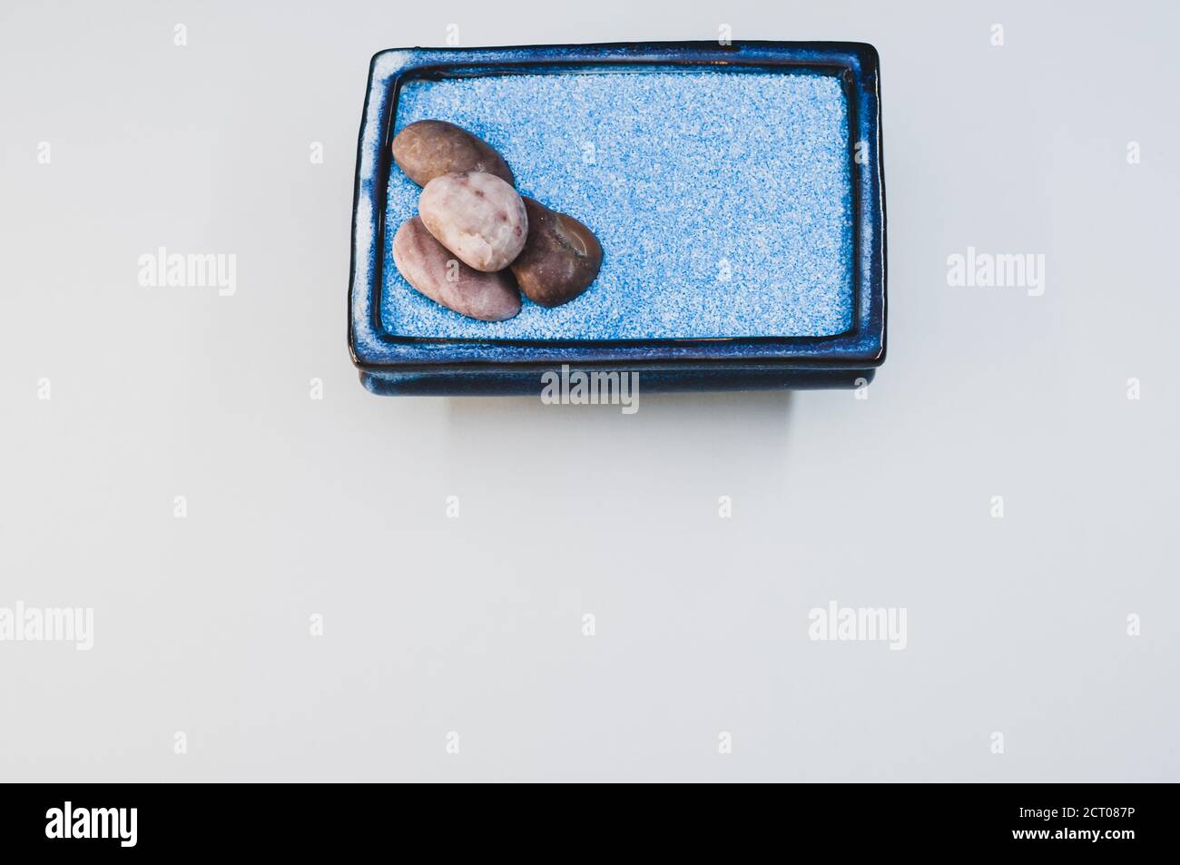 Top view of pebbles on a rectangular box filled with small blue rocks ...