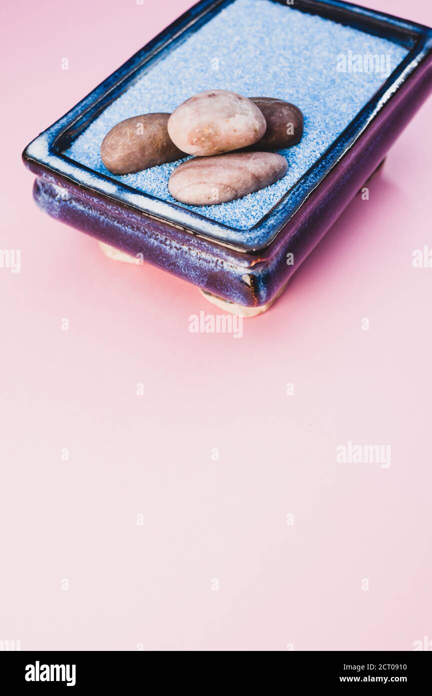 Vertical shot of pebbles on a rectangular box filled with small blue ...