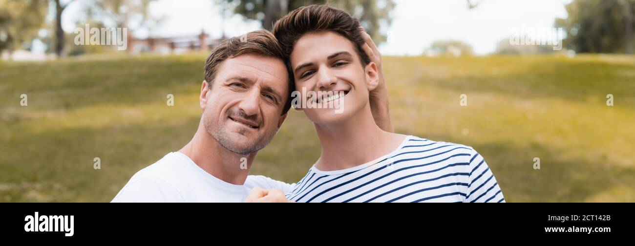 horizontal image of father and teenager son in park Stock Photo - Alamy