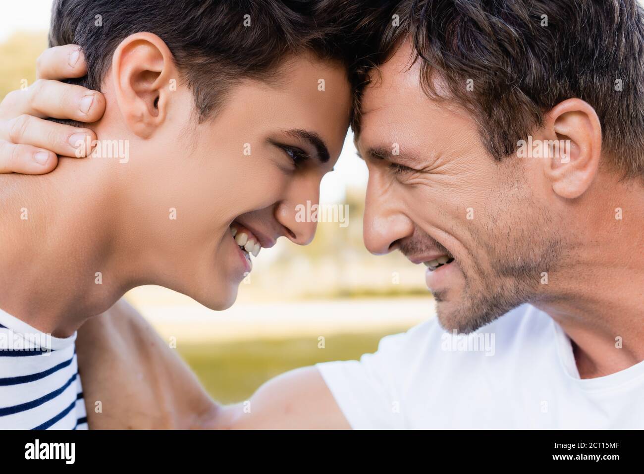 profile of joyful father and teenager son looking at each other Stock ...
