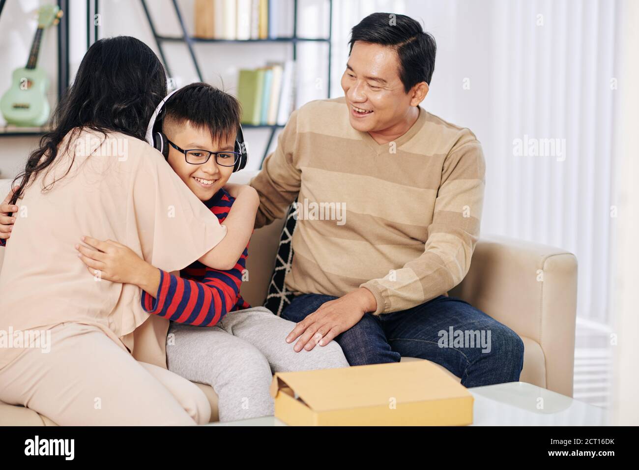 Happy boy hugging parents Stock Photo - Alamy