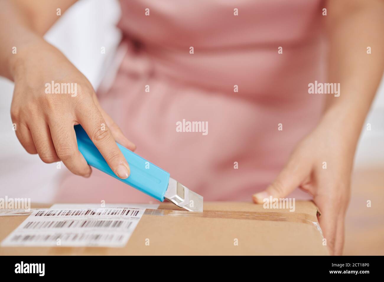 Woman opening cardboard box Stock Photo - Alamy