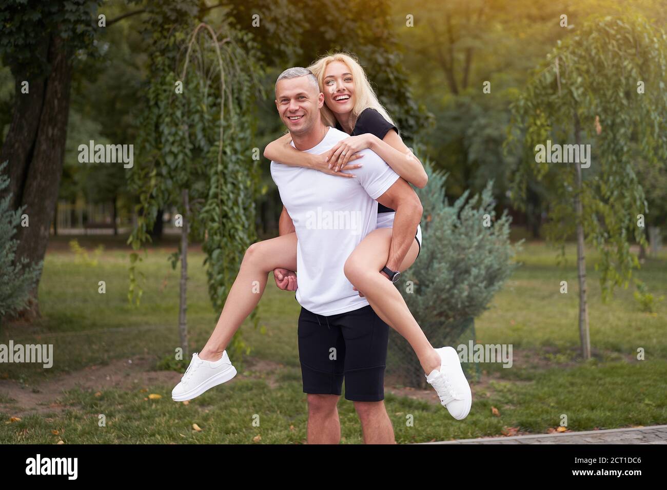 Piggy back ride playful woman man have fun outdoors summer park Happy ...