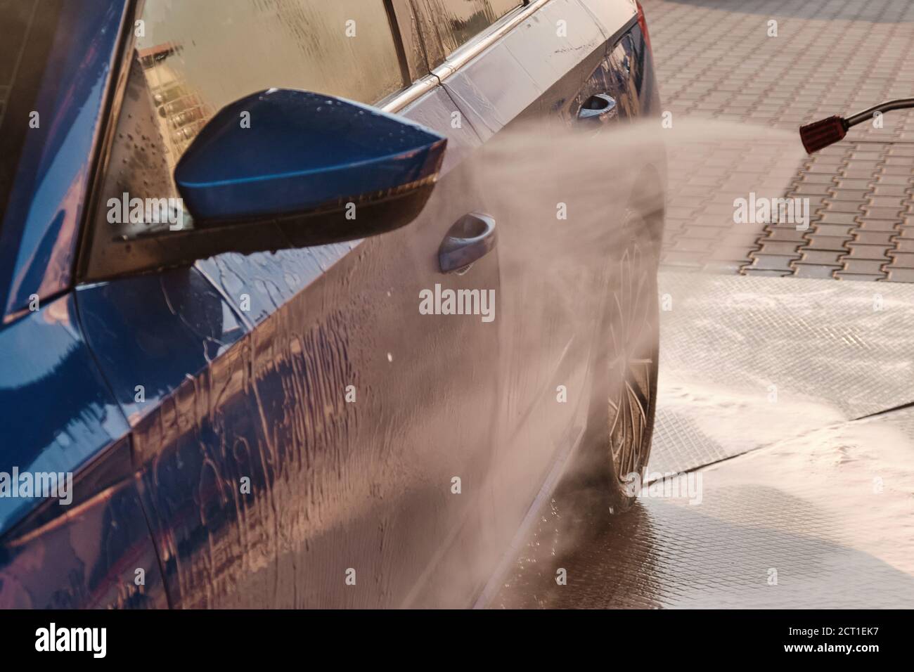 Manual car washing using a high pressure water. Side view of cleaning ...