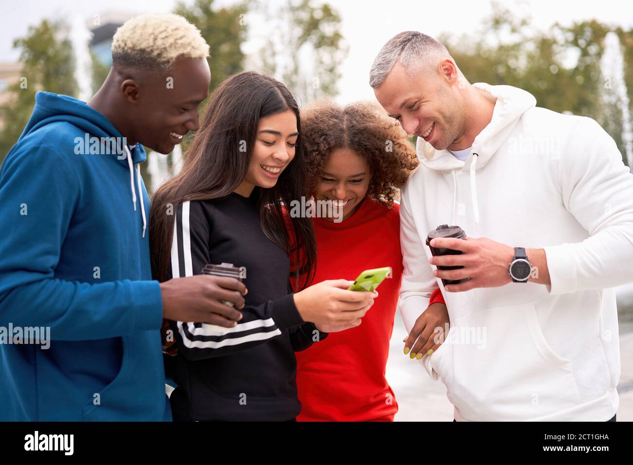 Multi-ethnic group teenage friends looking smartphone screen. African ...
