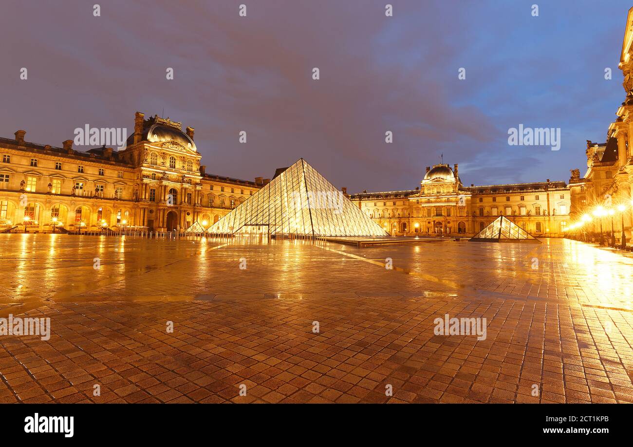 The Louvre pyramid view at rainy evening , Paris, France Stock Photo ...