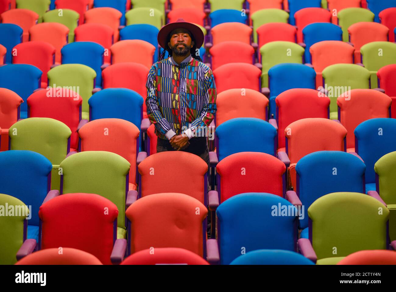 Single man inside empty auditorium with colorful seating Stock Photo ...