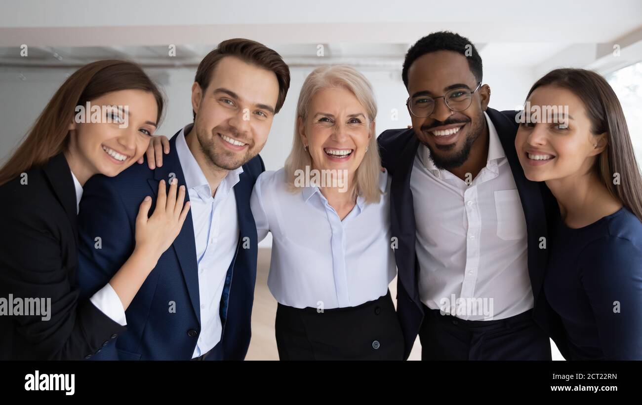 Portrait of smiling diverse colleagues hug posing in office Stock Photo ...