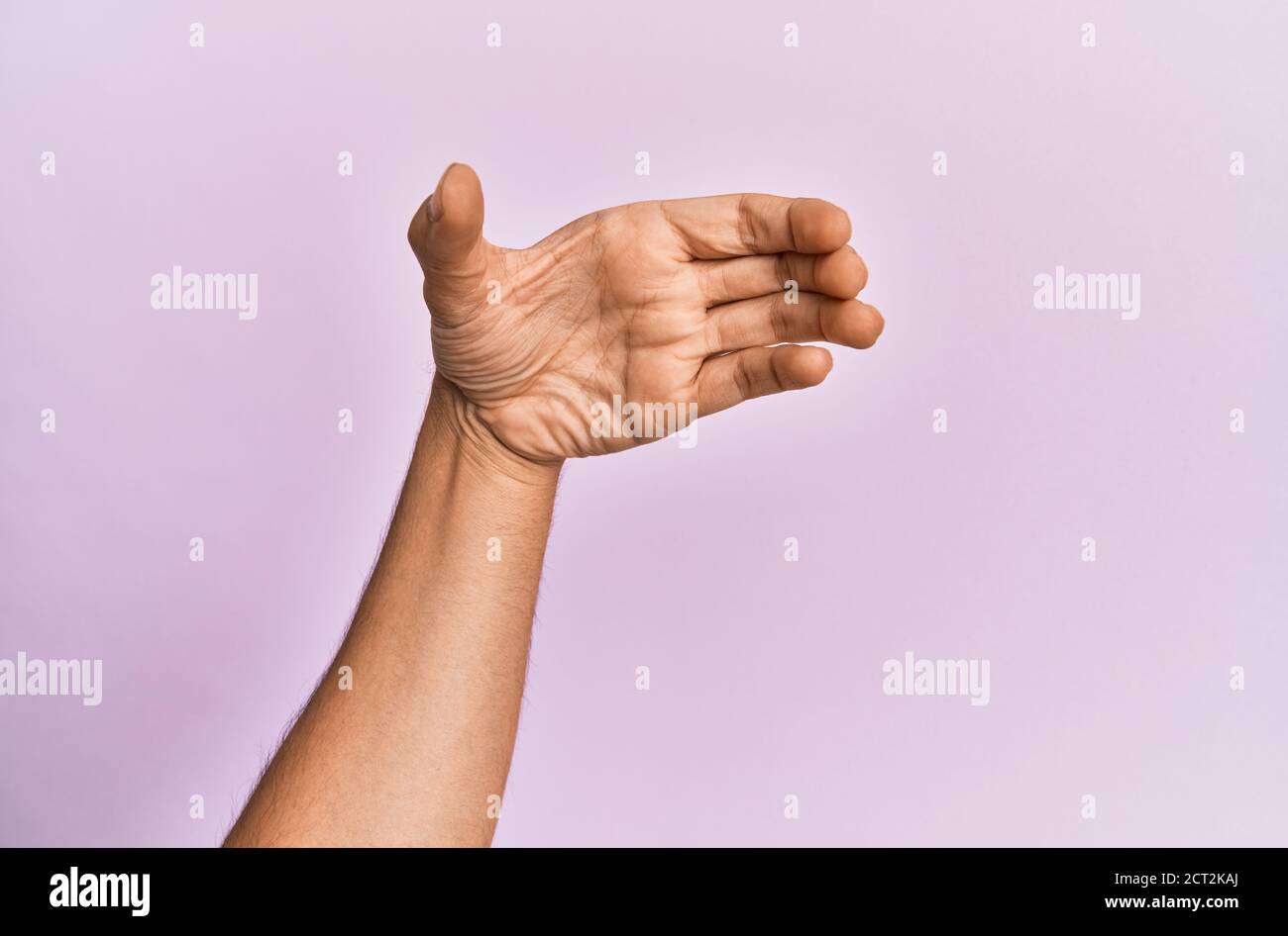 Arm and hand of caucasian young man over pink isolated background ...