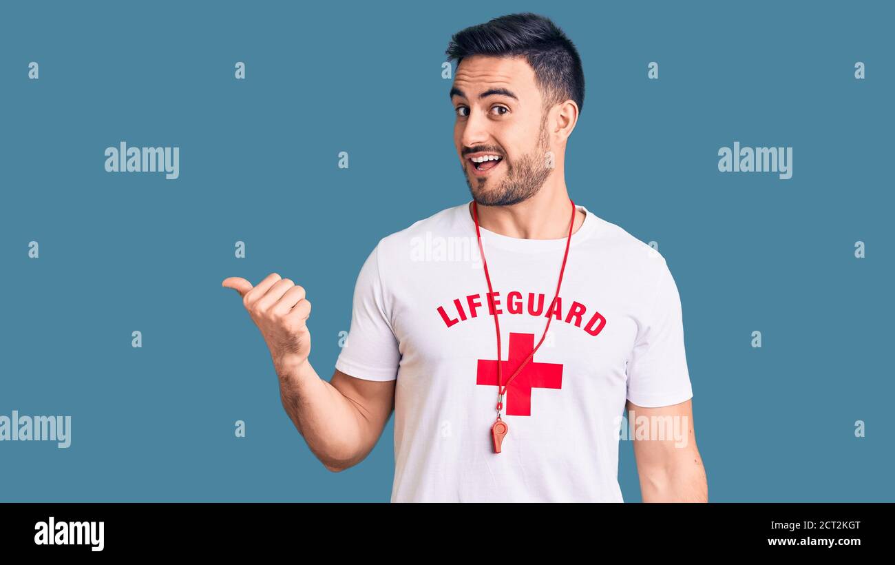 Young handsome man wearing lifeguard uniform smiling with happy face ...