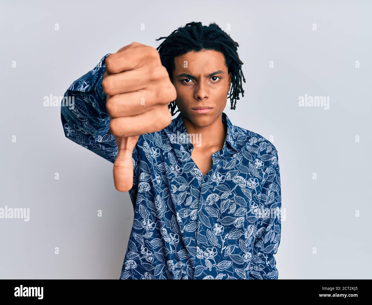 Young african american man wearing 80s style shirt looking unhappy and ...