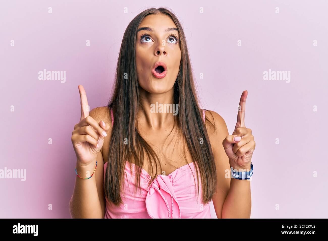 Young hispanic woman wearing casual style with sleeveless shirt amazed ...