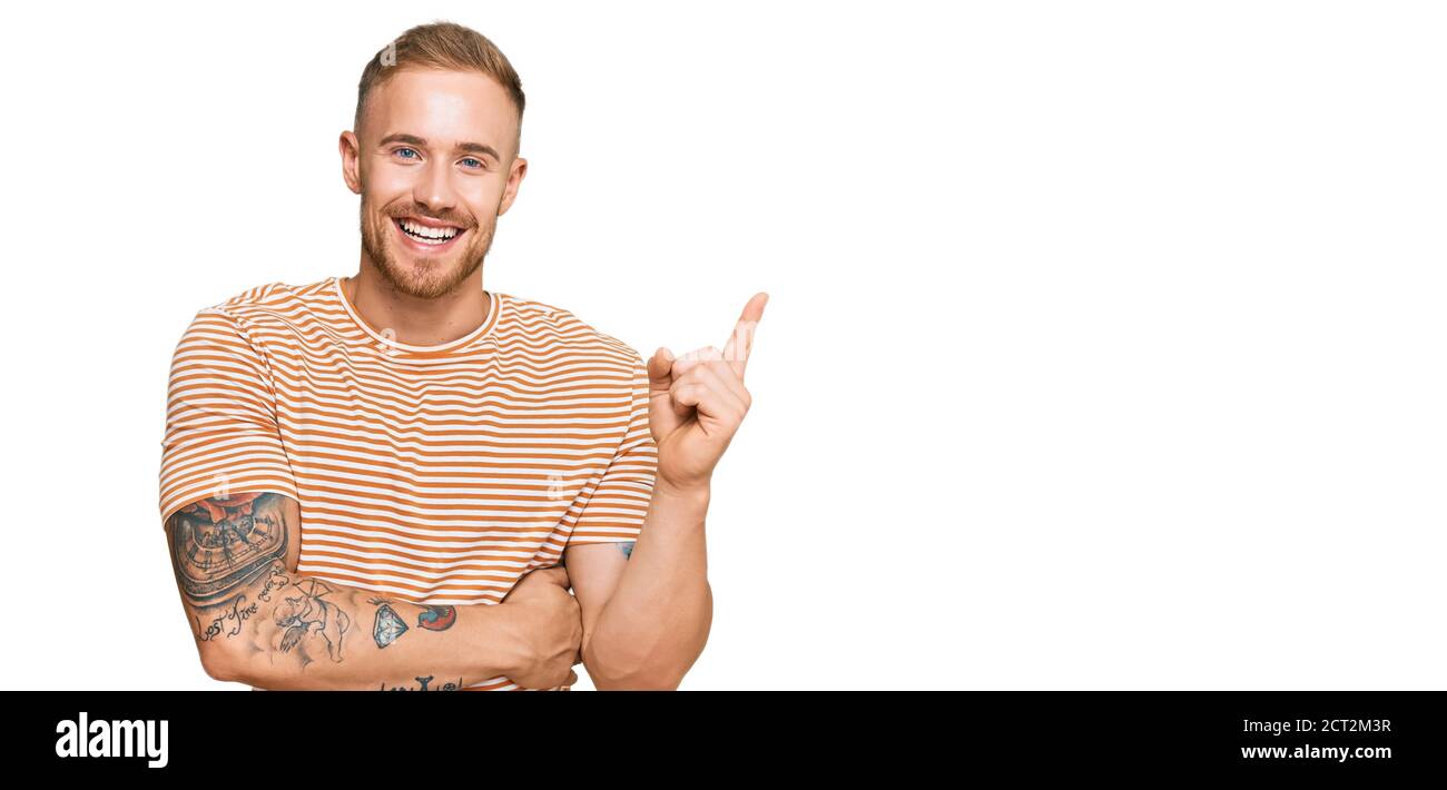 Young irish man wearing casual clothes smiling happy pointing with hand ...