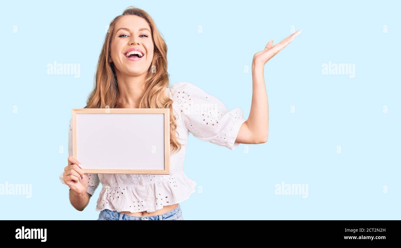 Young caucasian woman with blond hair holding blank empty banner ...