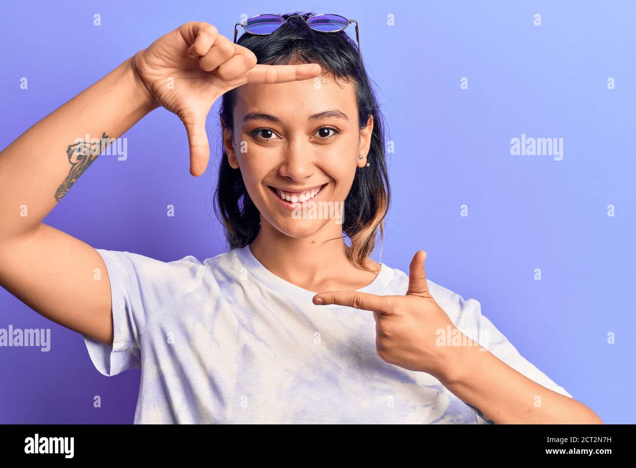 Young woman wearing casual clothes smiling making frame with hands and ...