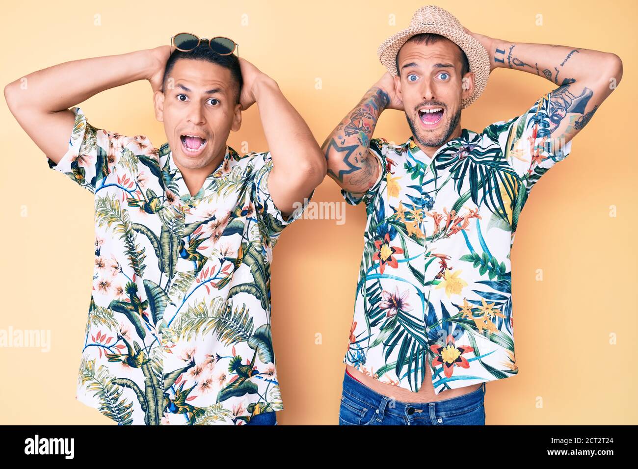 Young gay couple of two men wearing summer hat and hawaiian shirt crazy ...
