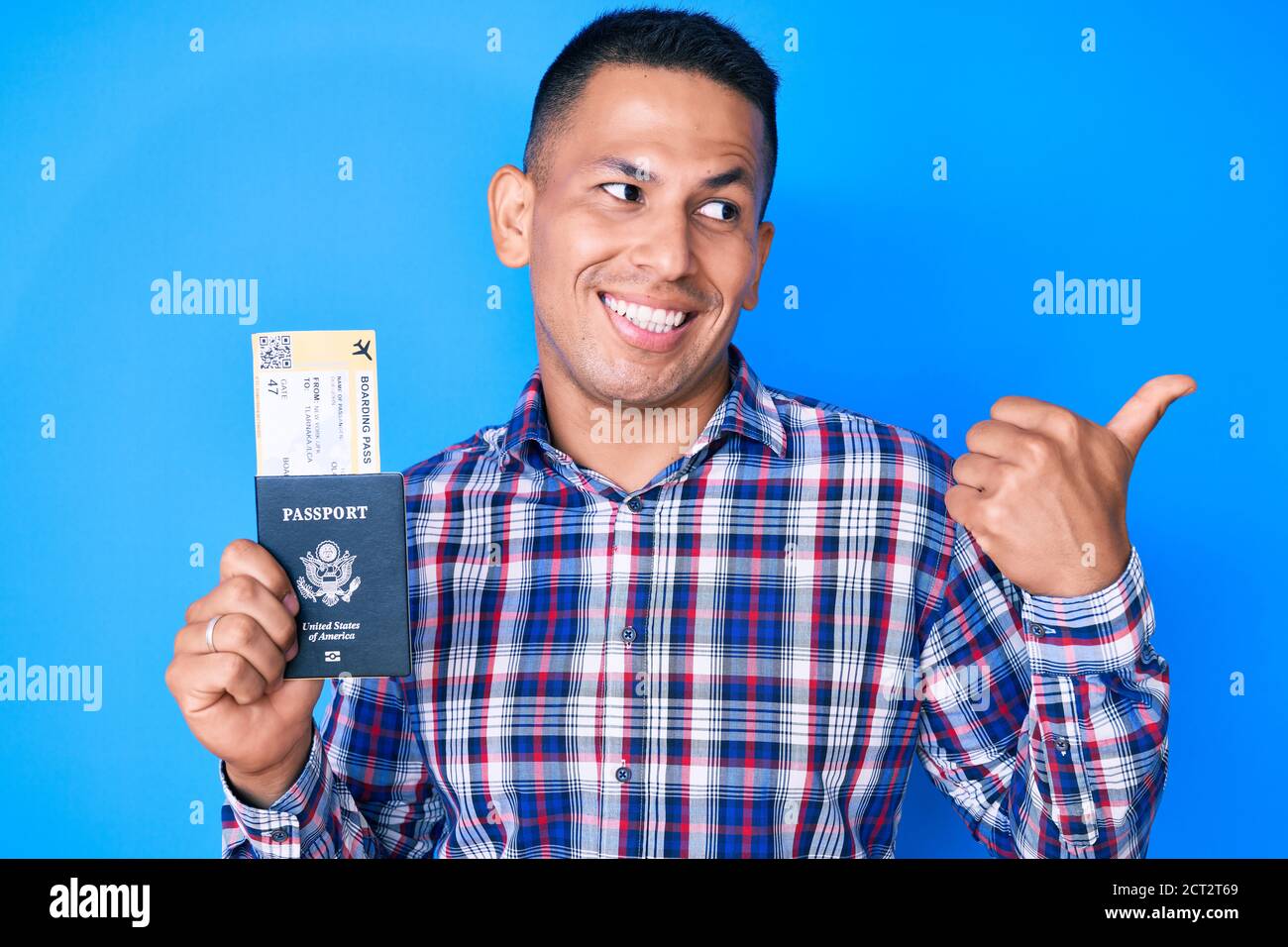 Young handsome latin man holding united states passport and boarding ...