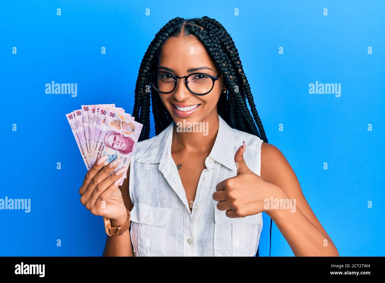 Beautiful hispanic woman holding 50 mexican pesos banknotes smiling ...