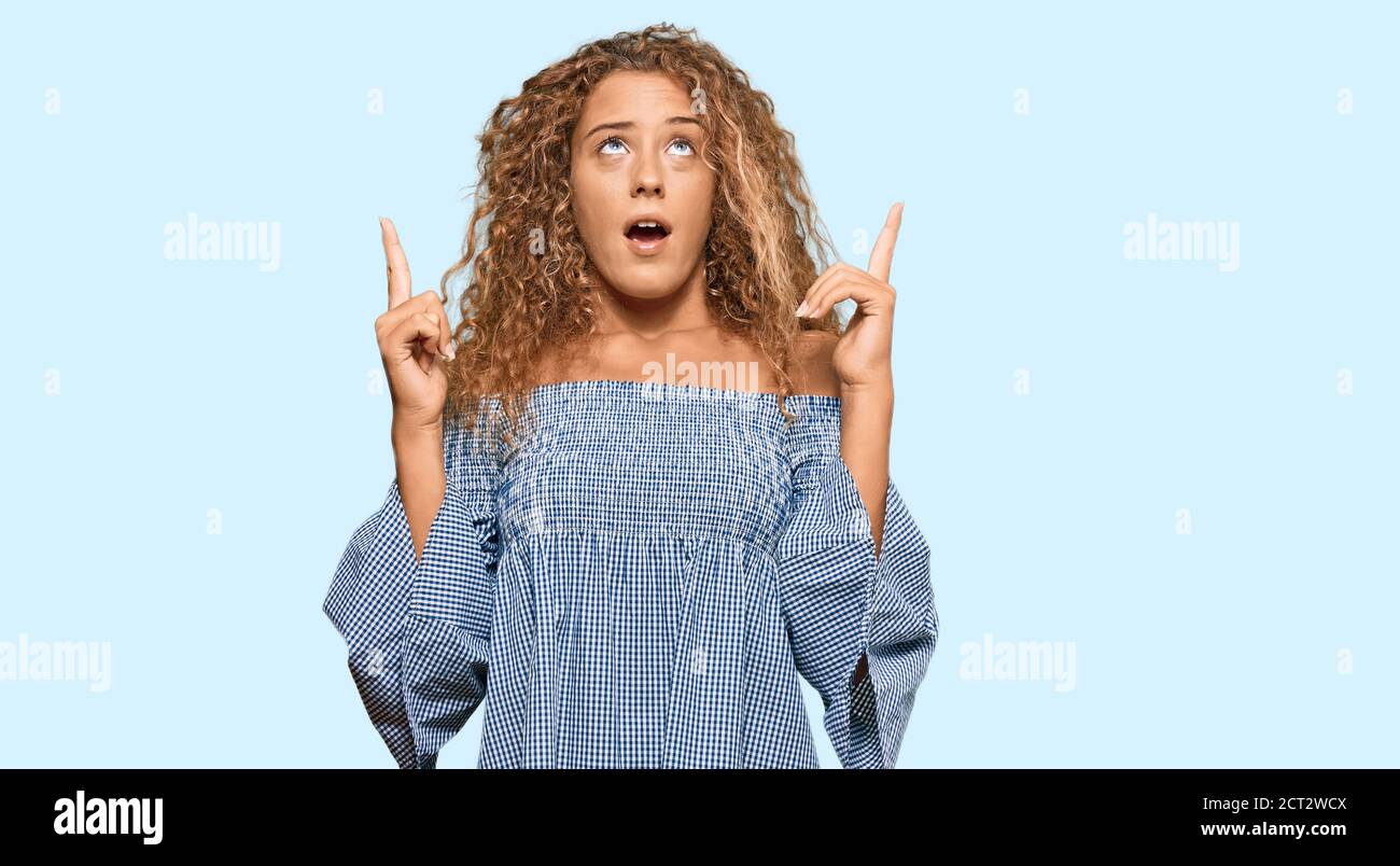 Beautiful caucasian teenager girl wearing summer dress amazed and ...