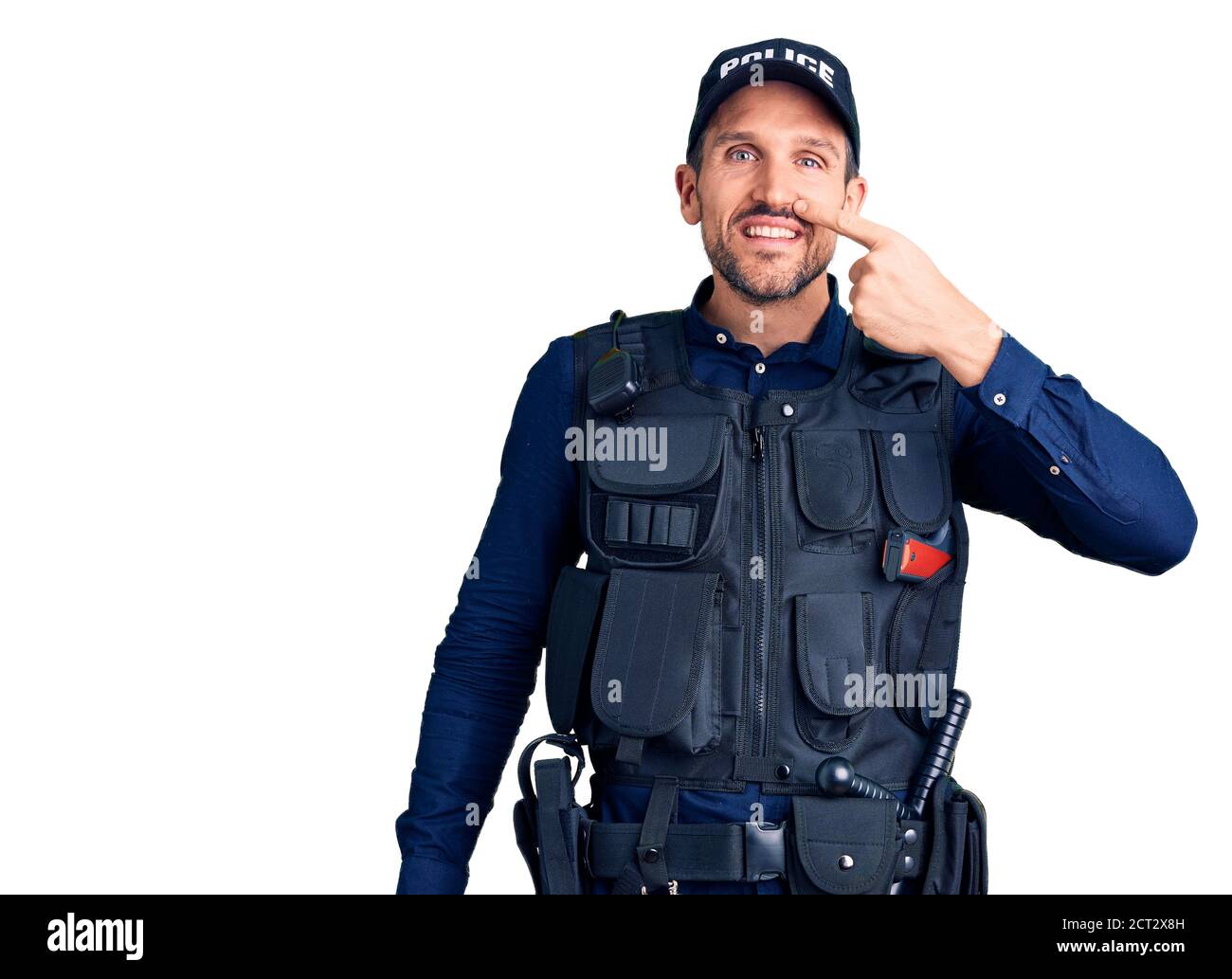 Young handsome man wearing police uniform pointing with hand finger to ...