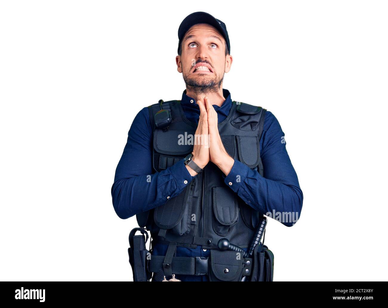 Young handsome man wearing police uniform begging and praying with ...