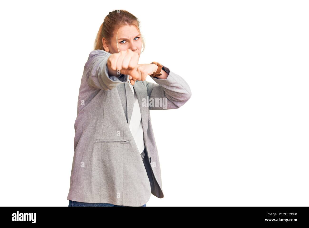 Young beautiful blonde woman wearing elegant jacket punching fist to ...