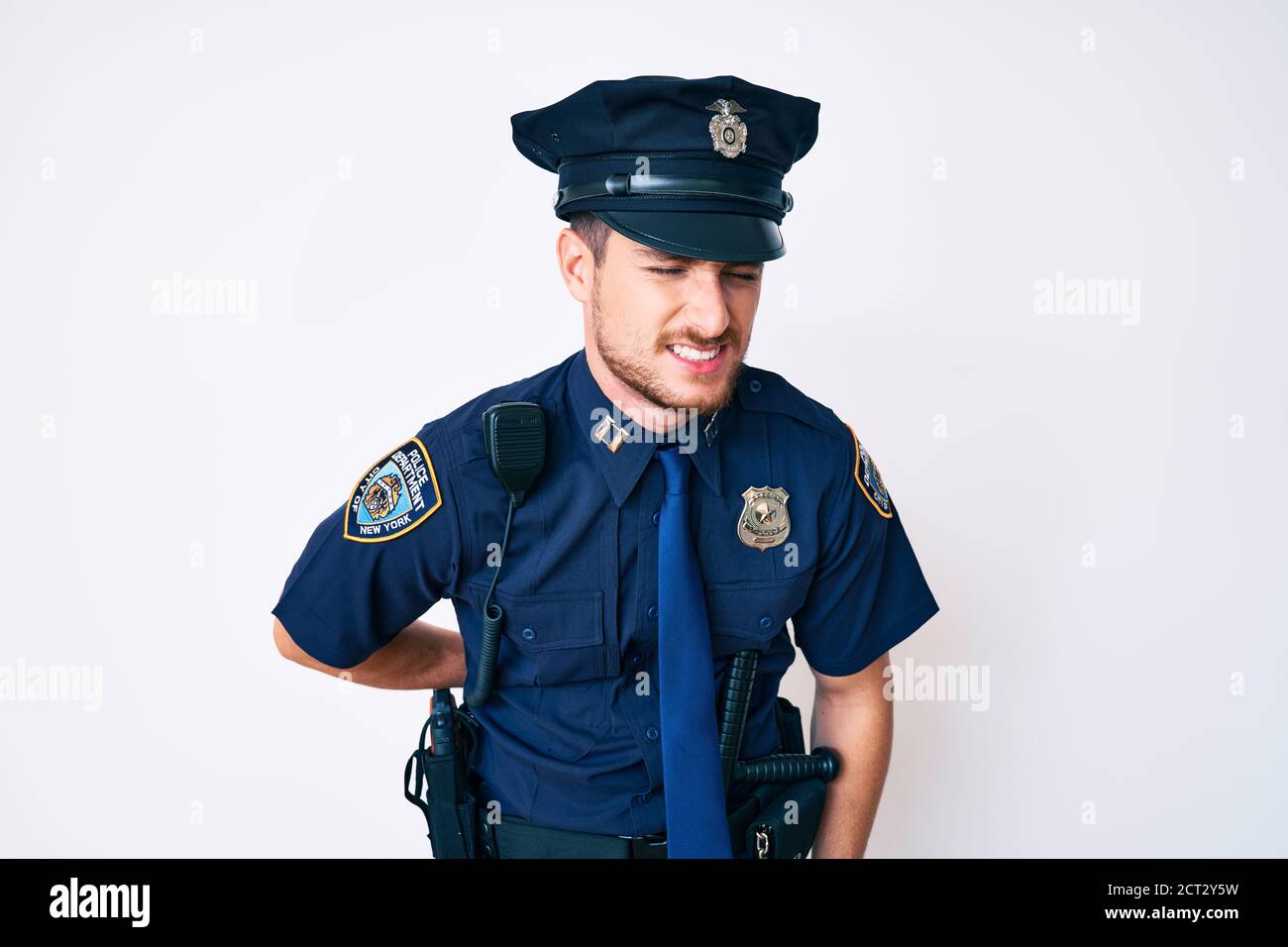 Young caucasian man wearing police uniform suffering of backache ...