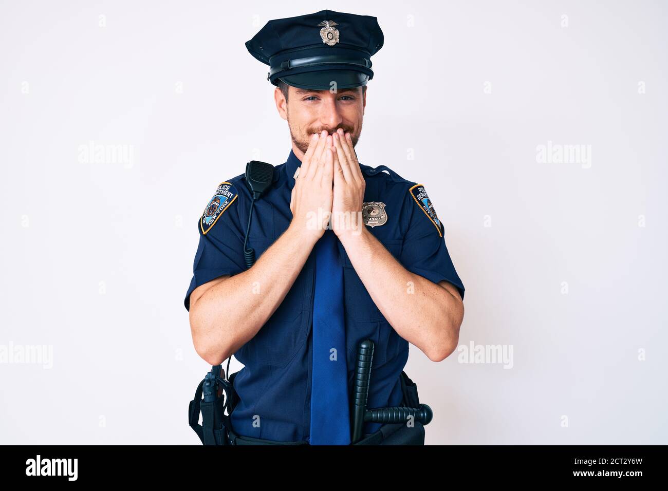 Young caucasian man wearing police uniform laughing and embarrassed ...