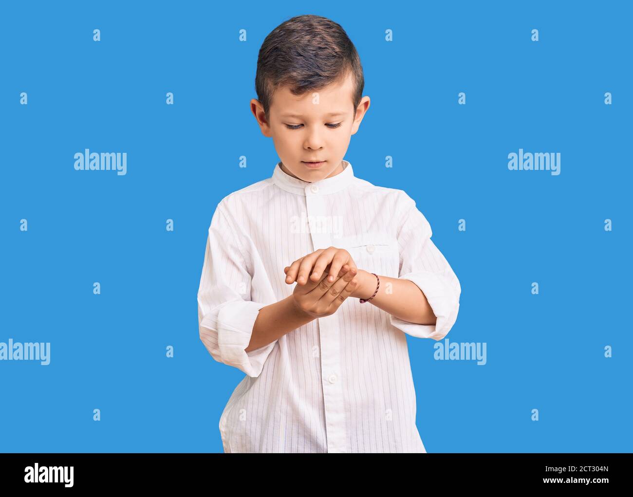 Cute blond kid wearing elegant shirt suffering pain on hands and ...