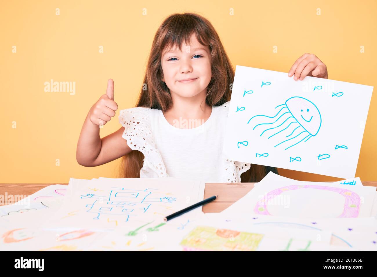 Little caucasian kid girl with long hair drawing colorful paintings ...