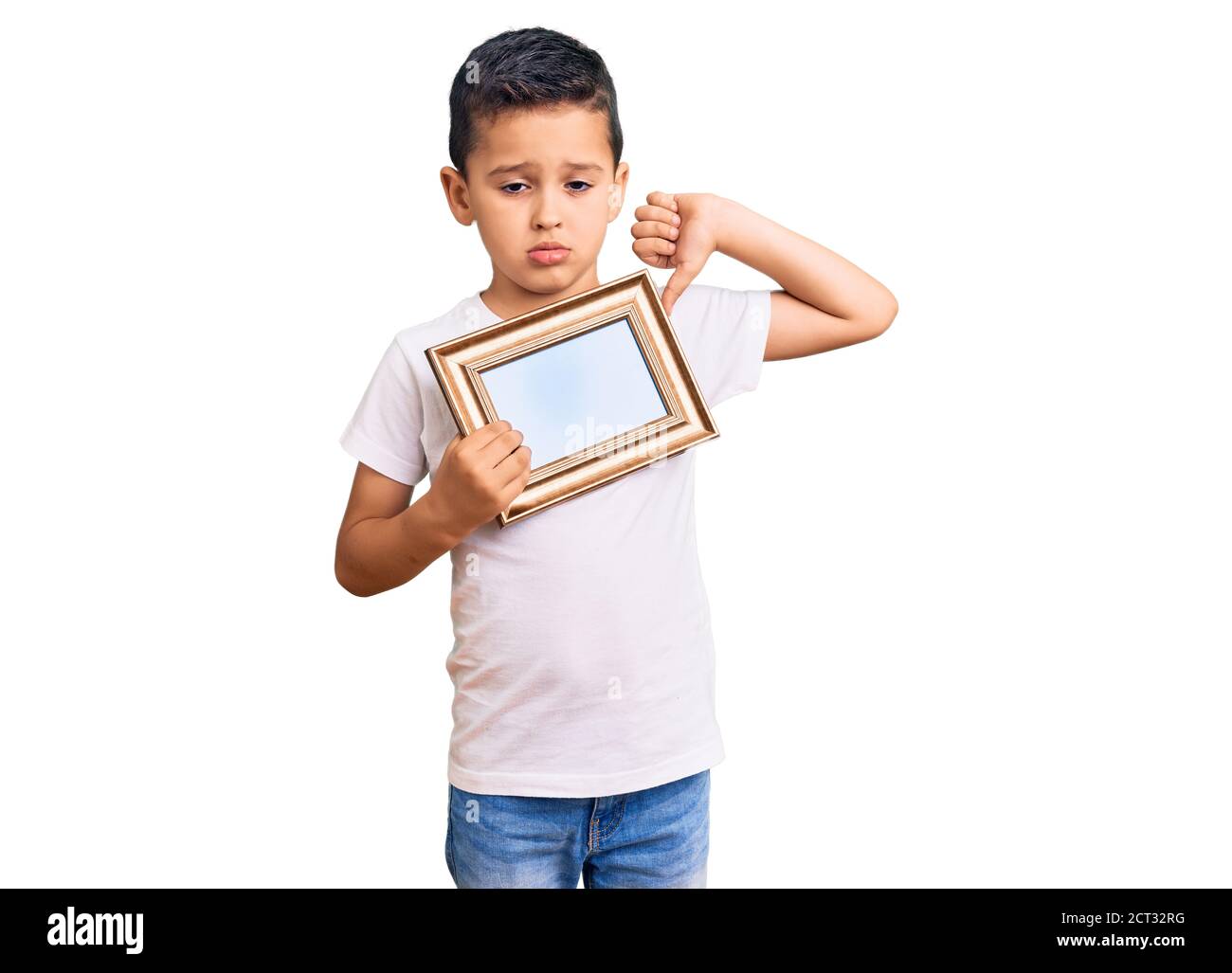 Little cute boy kid holding empty frame with angry face, negative sign ...