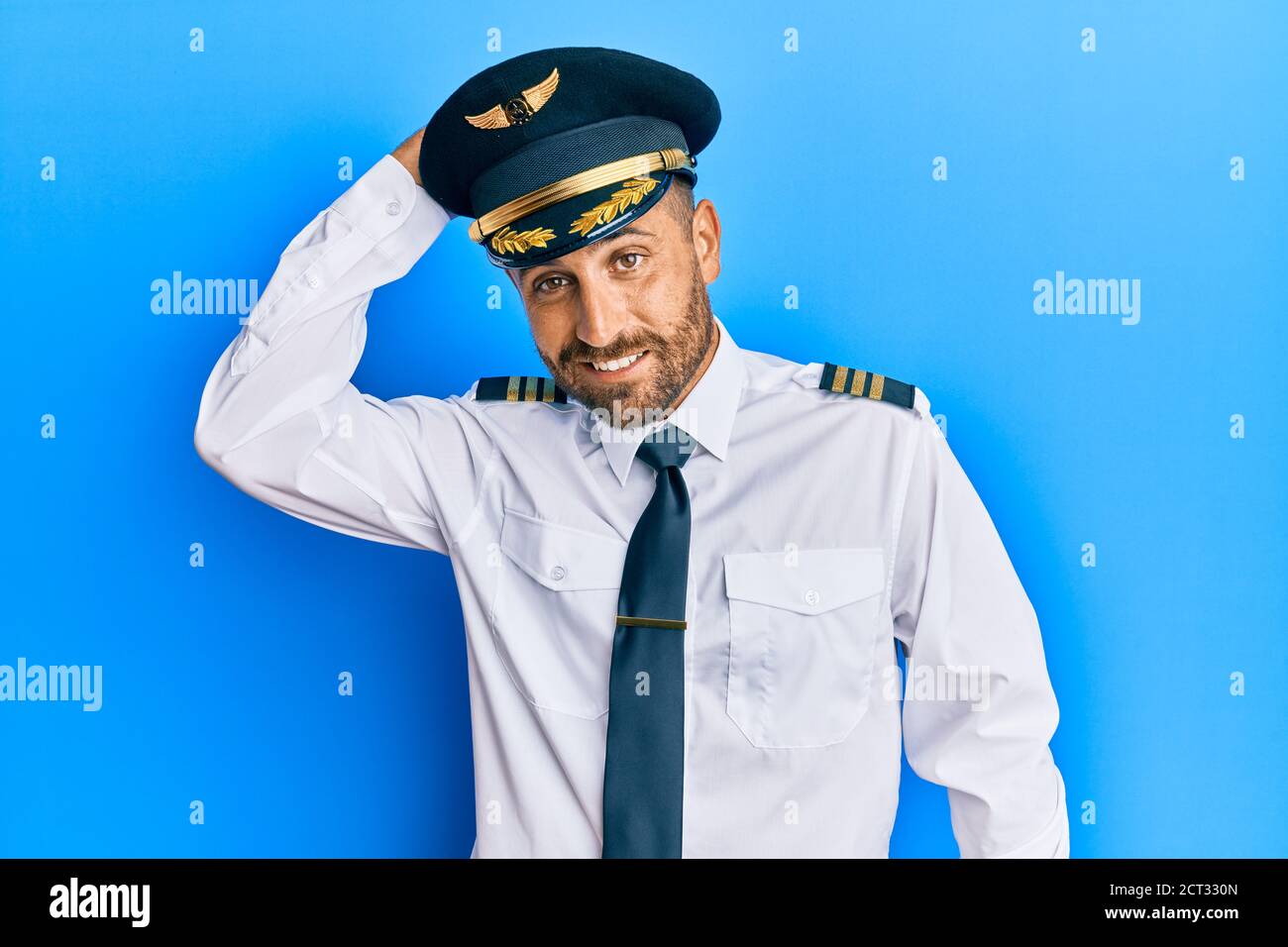 Handsome man with beard wearing airplane pilot uniform confuse and ...