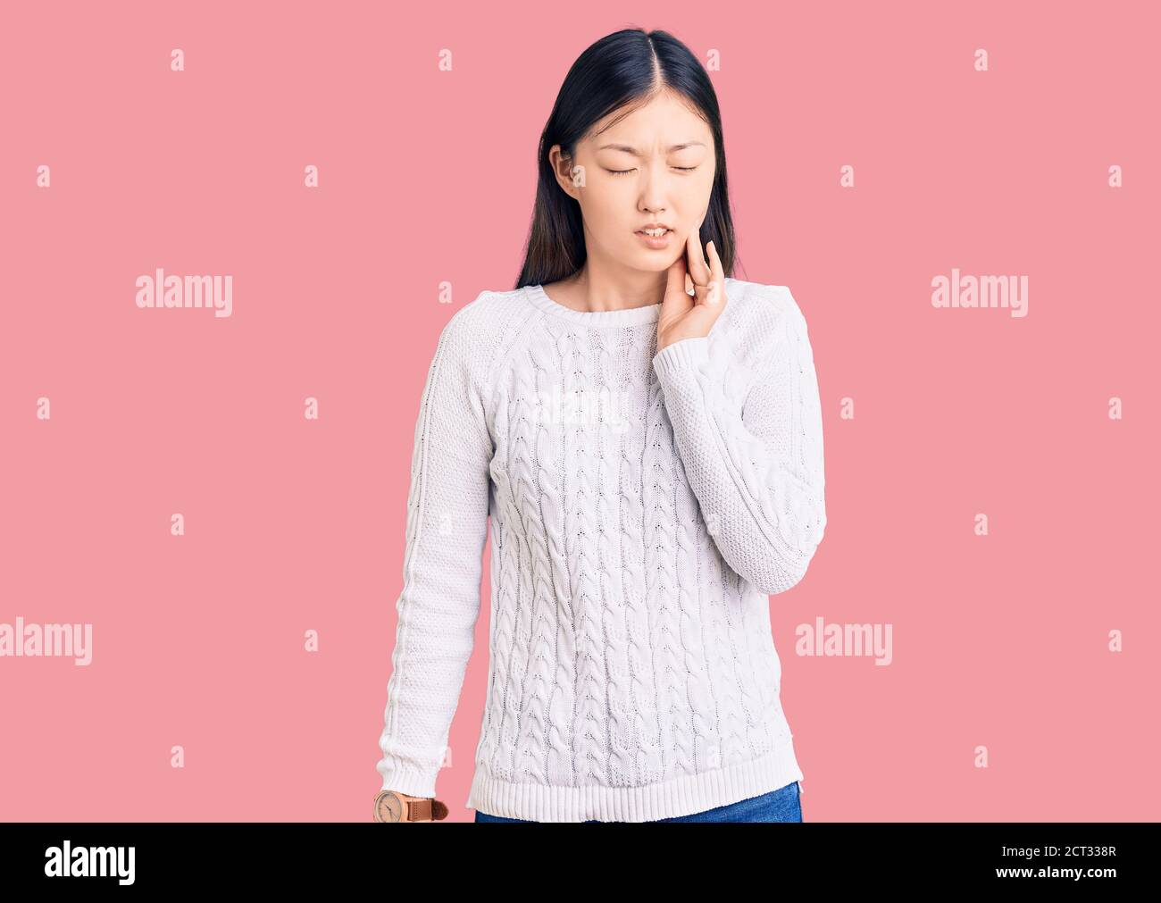 Young beautiful chinese woman wearing casual sweater touching mouth ...
