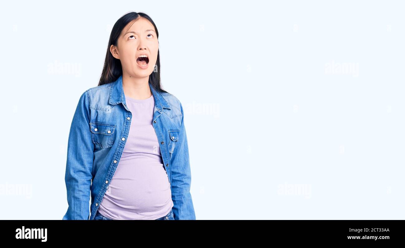 Young beautiful chinese woman pregnant expecting baby angry and mad ...