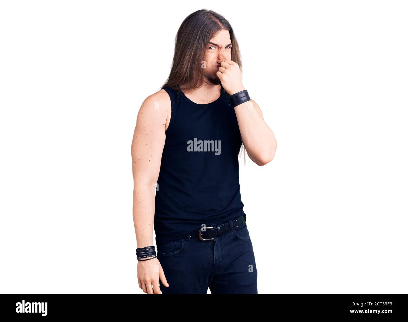 Young adult man with long hair wearing goth style with black clothes ...