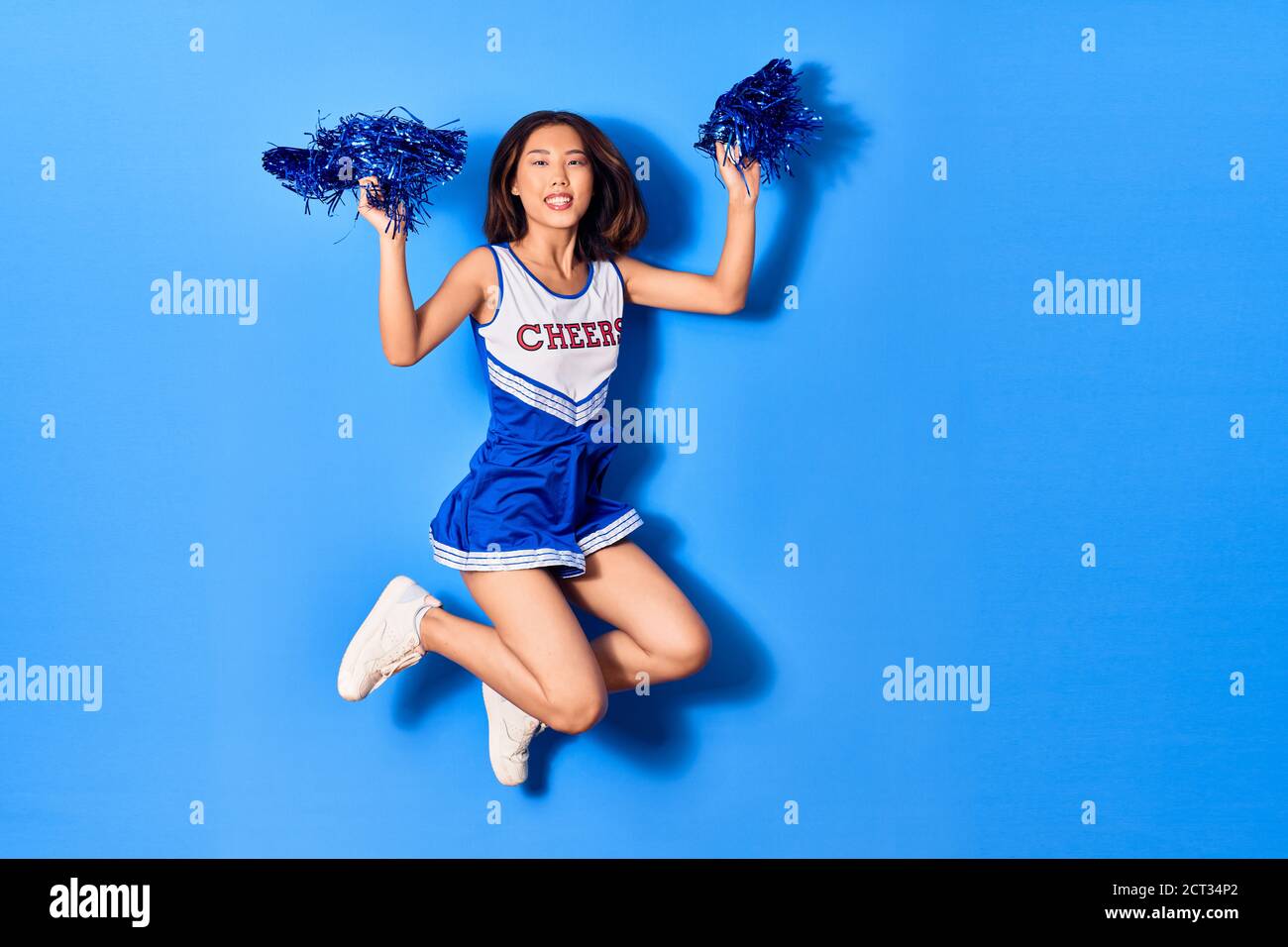 Young beautiful chinese girl smiling happy wearing cheerleader uniform ...