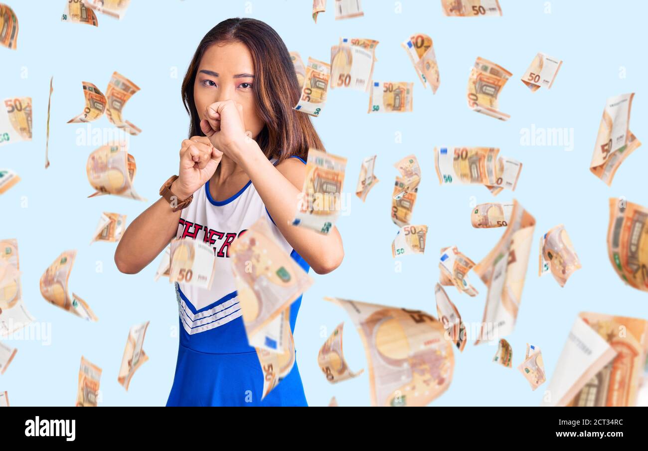 Young beautiful chinese girl wearing cheerleader uniform ready to fight ...