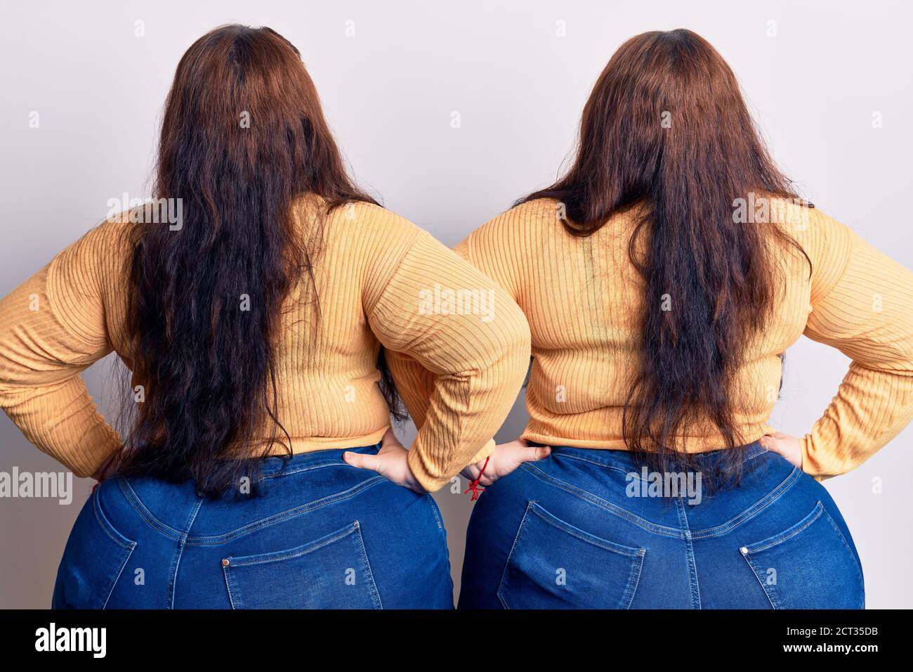 Young plus size twins wearing casual clothes standing backwards looking ...