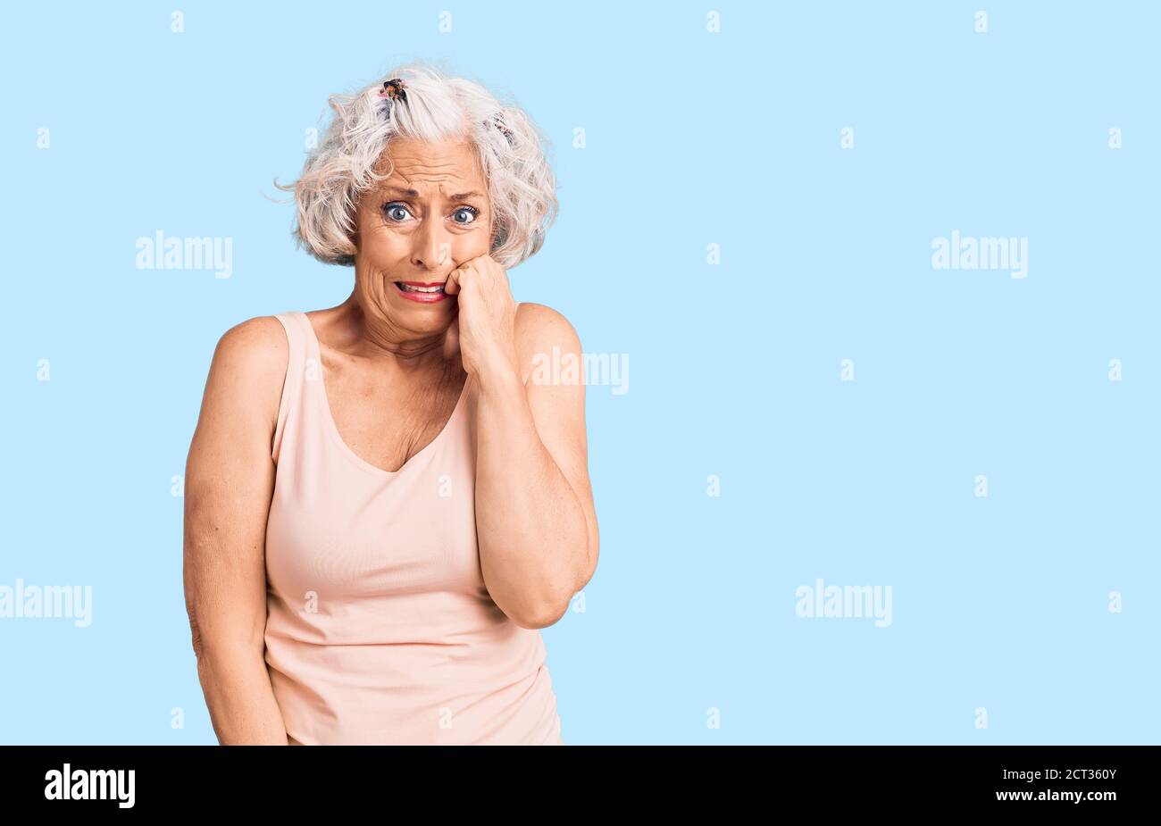 Senior grey-haired woman wearing casual clothes looking stressed and ...