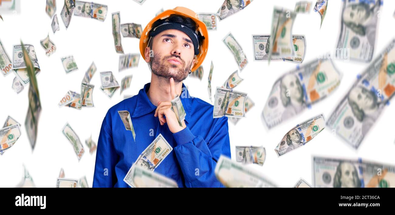 Young hispanic man wearing worker uniform thinking concentrated about ...
