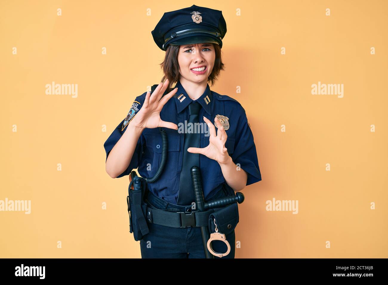 Young beautiful woman wearing police uniform disgusted expression ...