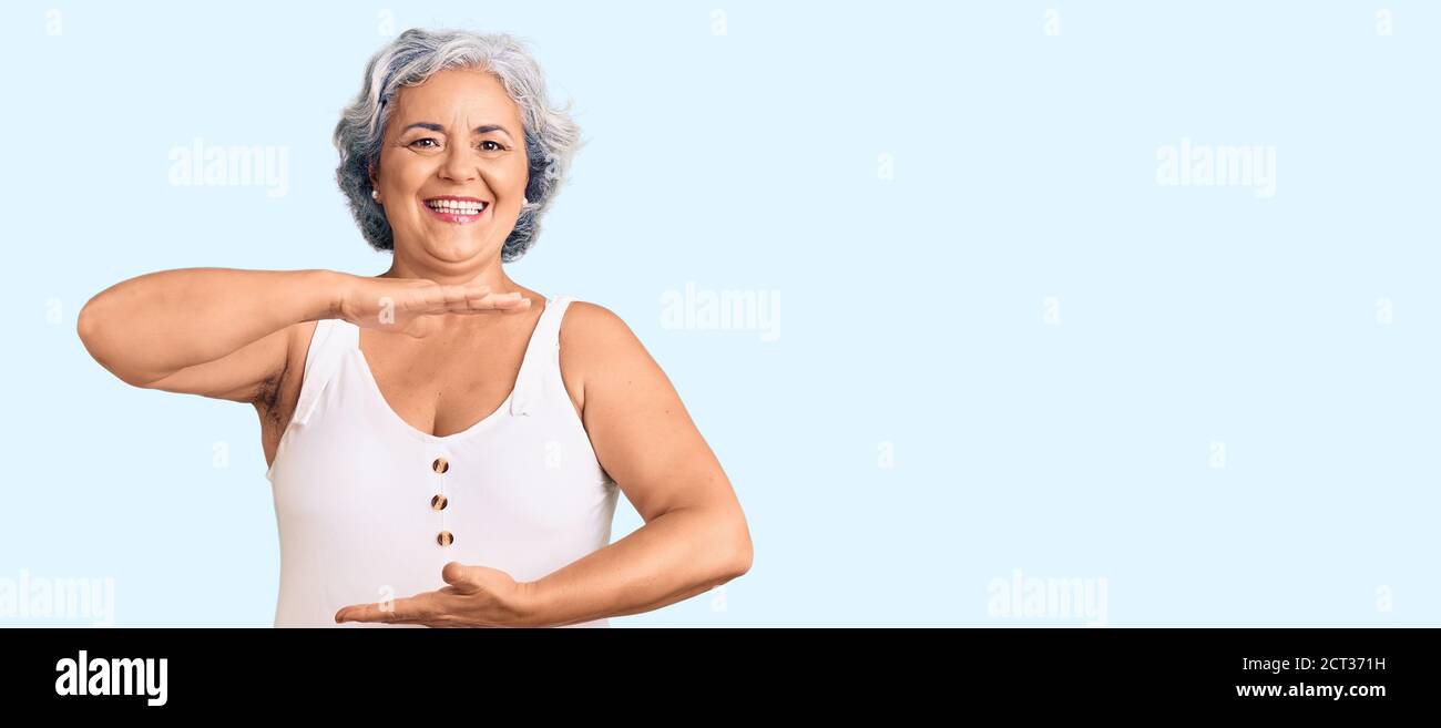 Senior woman with gray hair wearing casual clothes gesturing with hands ...
