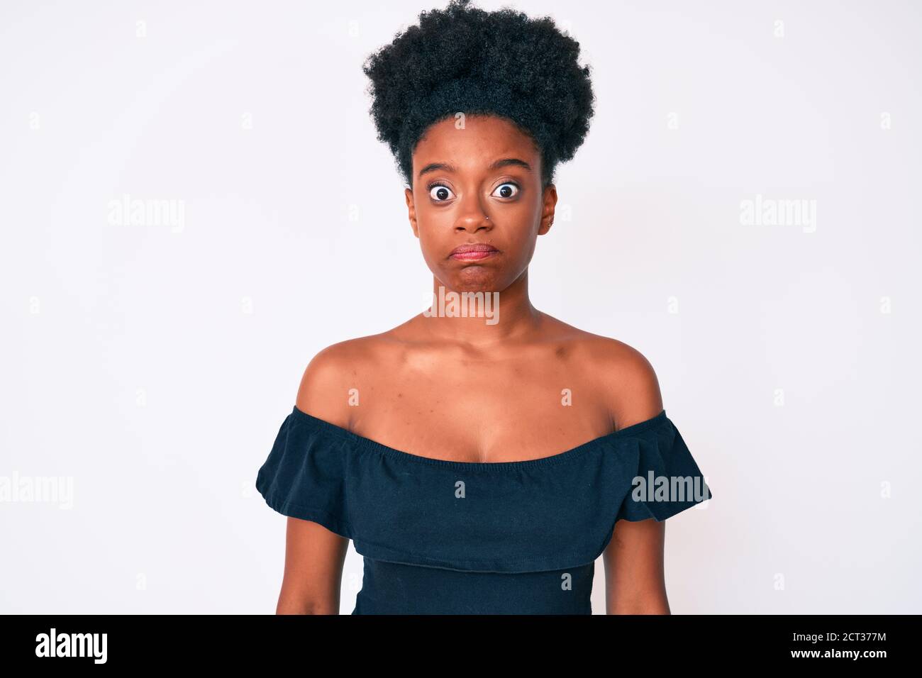 Young african american woman wearing casual clothes puffing cheeks with ...