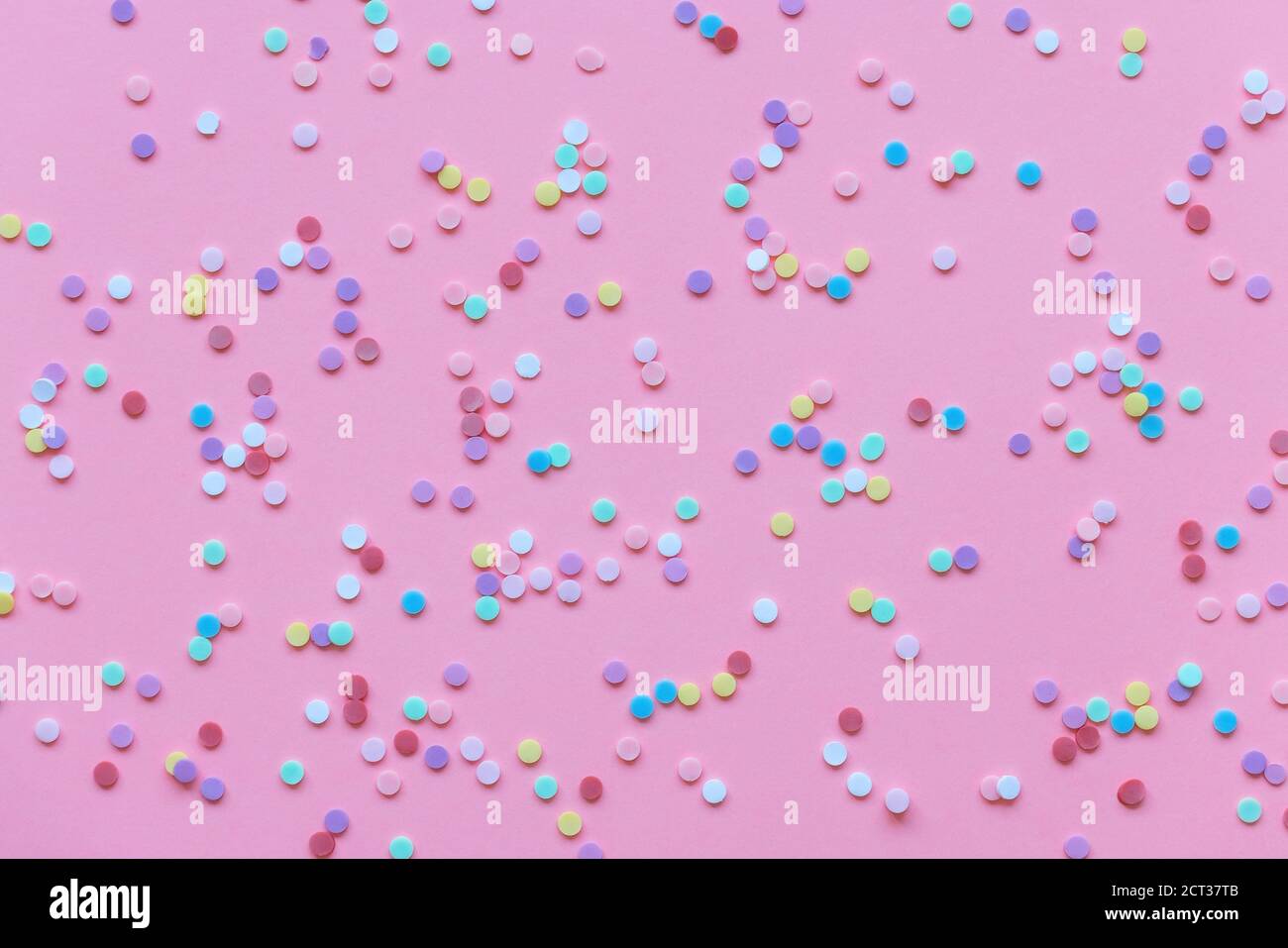 Plastic colorful confetti on a pink background Stock Photo - Alamy