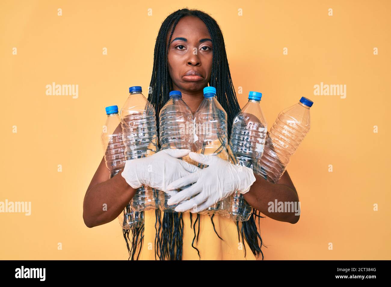 African american woman with braids holding recycling plastic bottles ...
