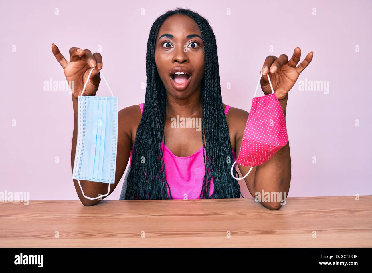 African american woman with braids holding two different safety masks ...